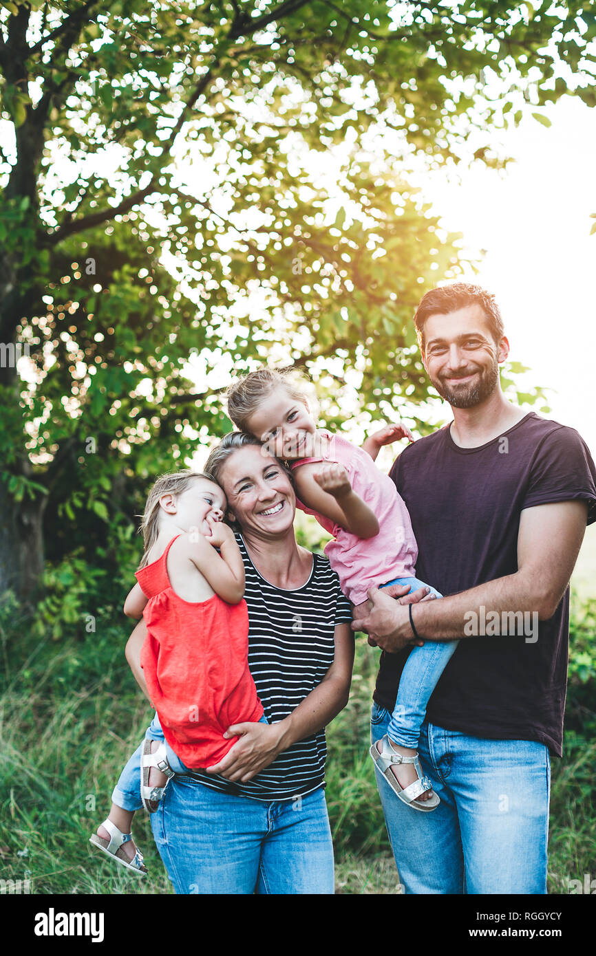 Portrait of happy family with two daughters standing in nature Stock ...