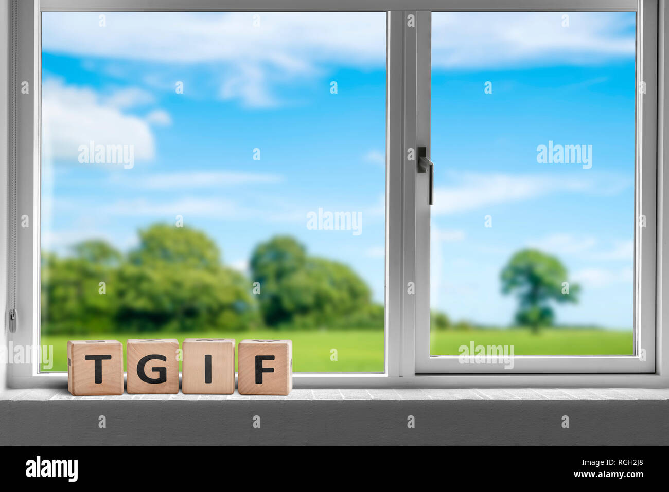 TGIF weekend sign in a white window with a view to sunshine over a ...