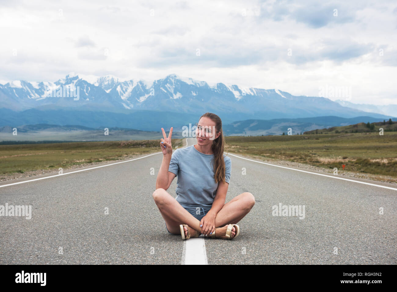 Woman sitting on the road Stock Photo - Alamy