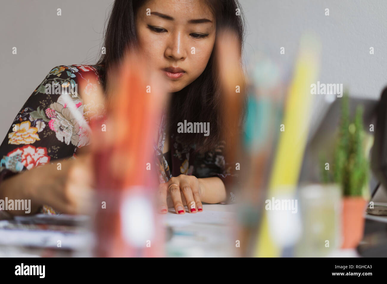 Illustrator drawing at work desk in an atelier Stock Photo - Alamy