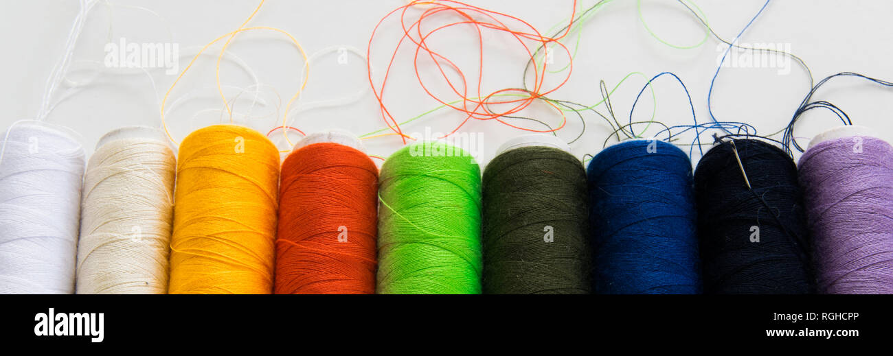 Top view of colorful sewing threads on white background, space for text ...