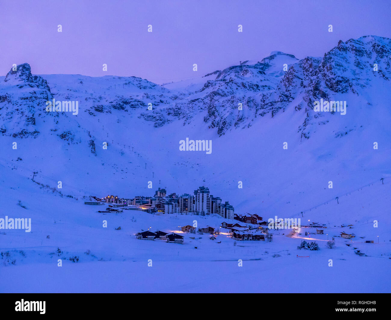 Snow covered Tignes Val Claret from lake at dusk with a pink sky behind ...