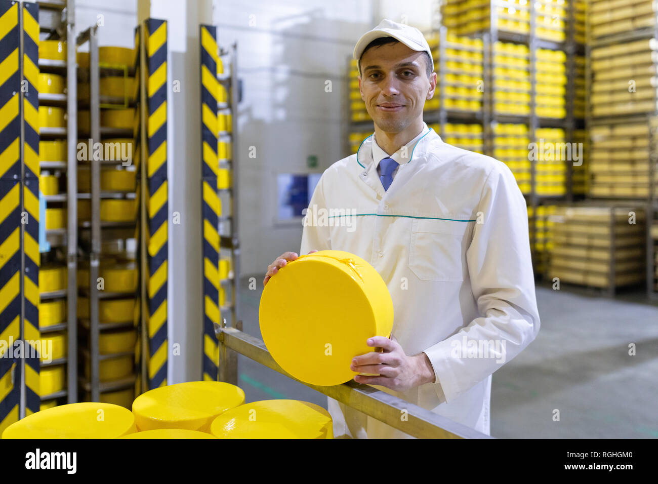 man holding a head of cheese at a dairy plant Stock Photo - Alamy