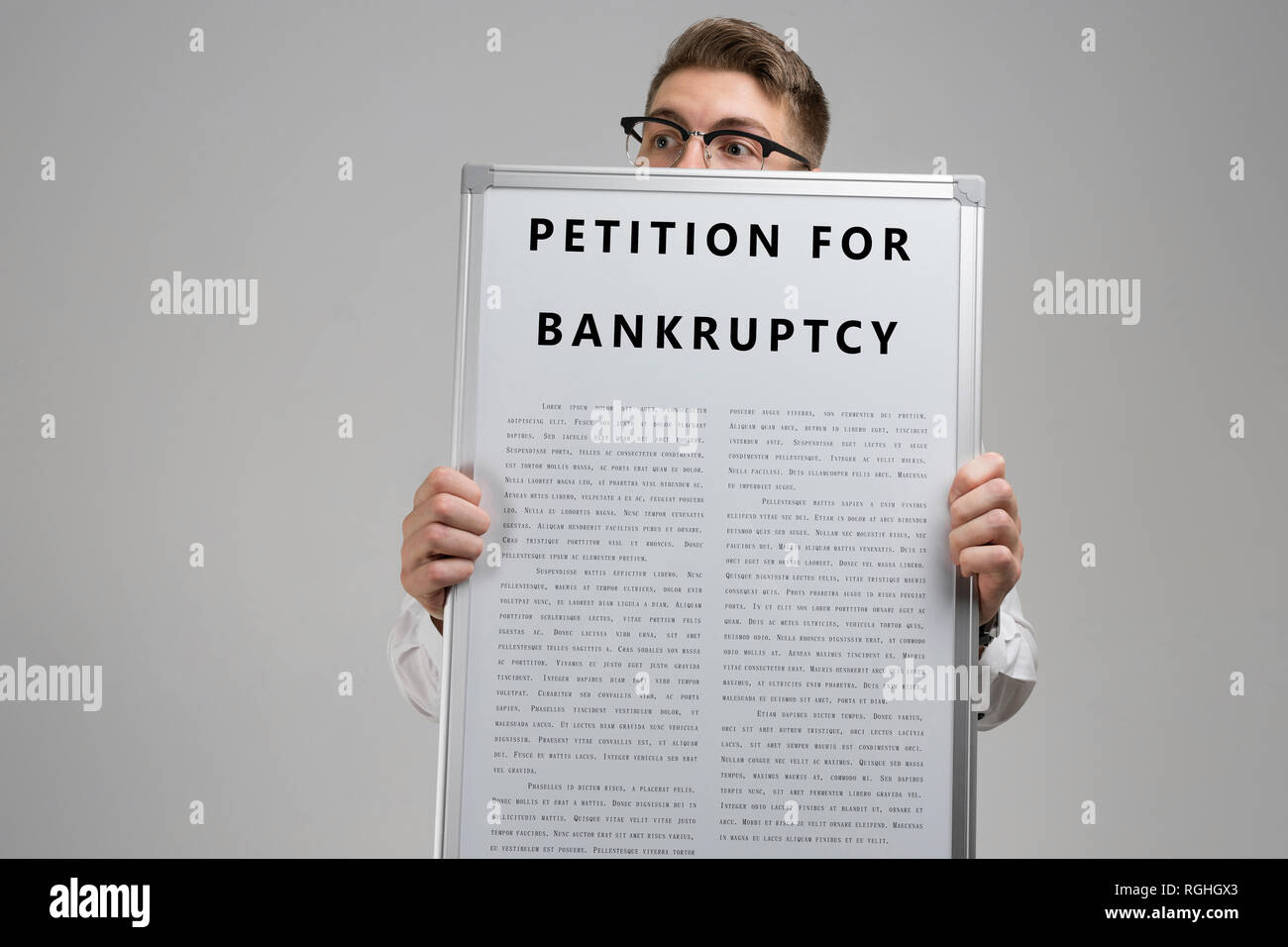 Young man keeps in front of him petition for bankruptcy isolated on ...