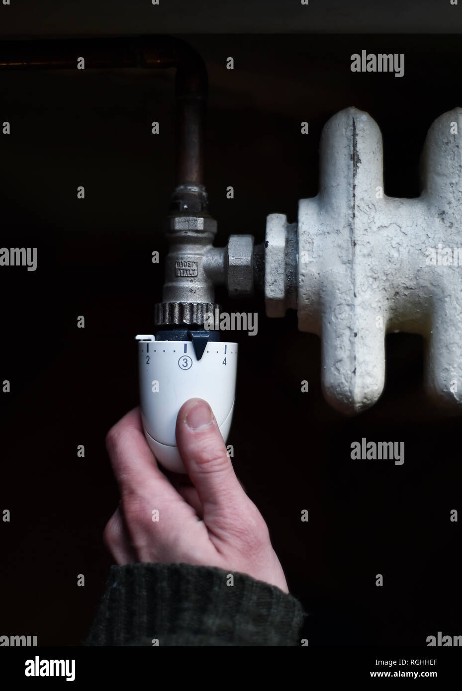 Detail with a hand checking the heat coming from a household radiator ...