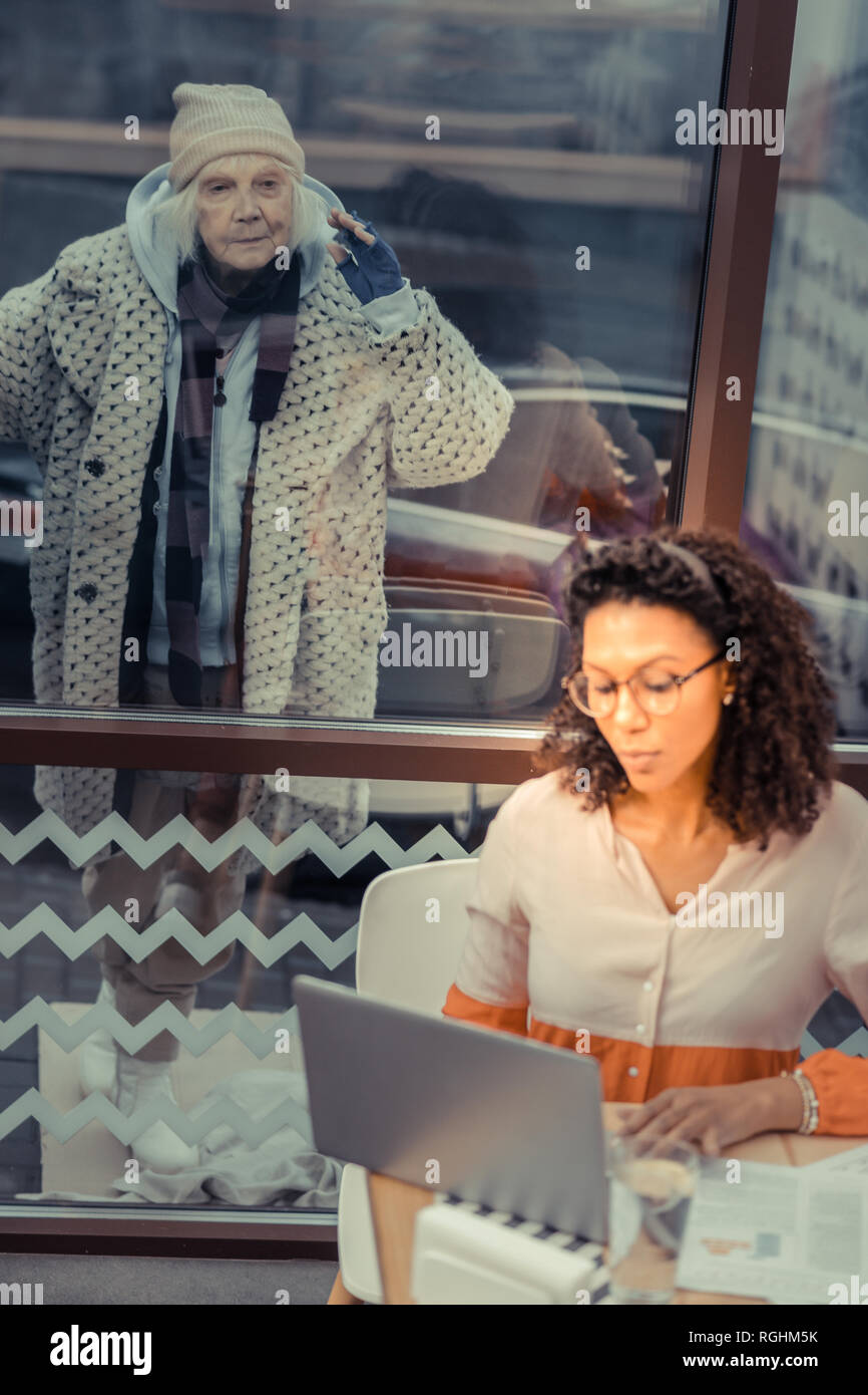 Sad senior woman looking into the window Stock Photo - Alamy