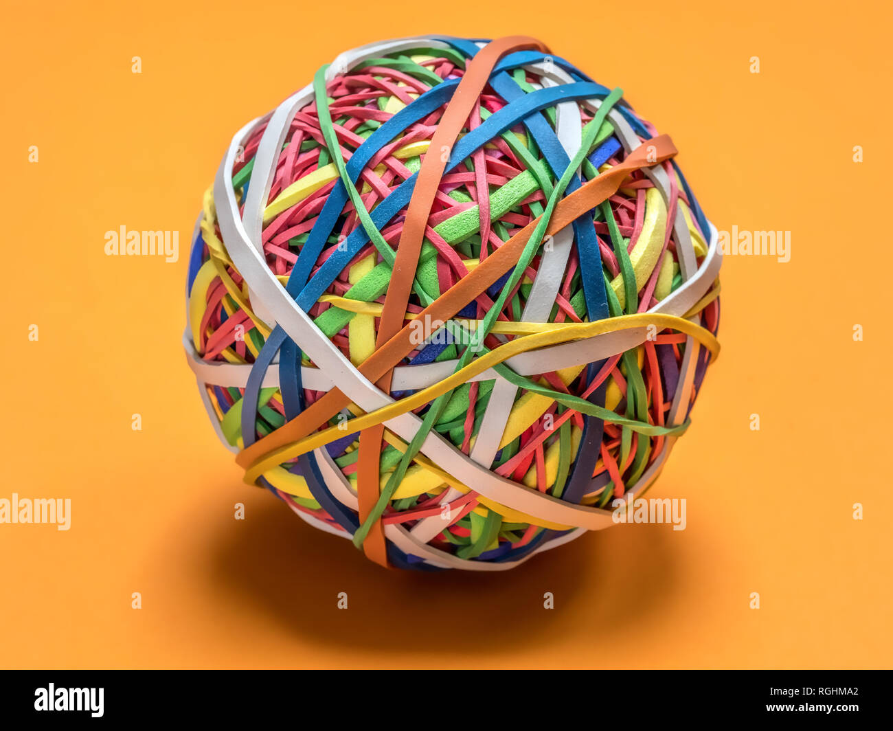Colorful rubber band ball on orange background Stock Photo - Alamy