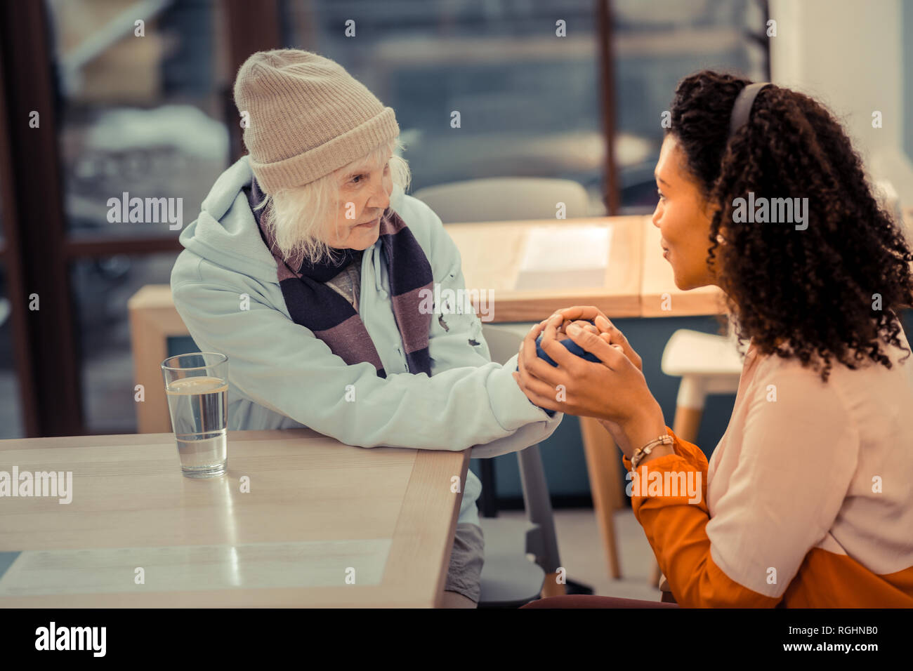Nice pleasant women holding each others hands Stock Photo - Alamy