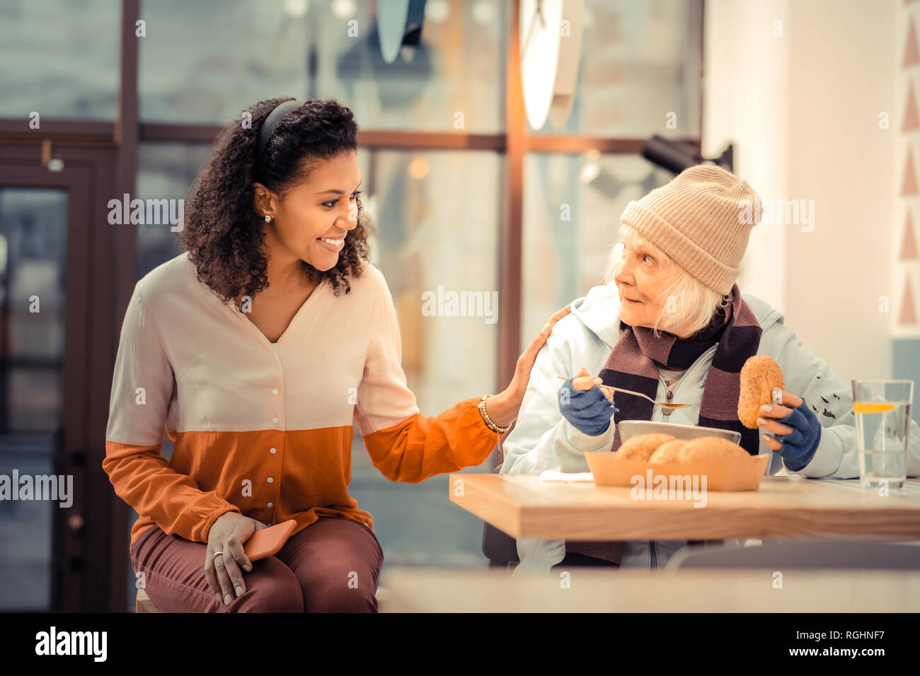 Joyful friendly woman sitting near her guest Stock Photo - Alamy