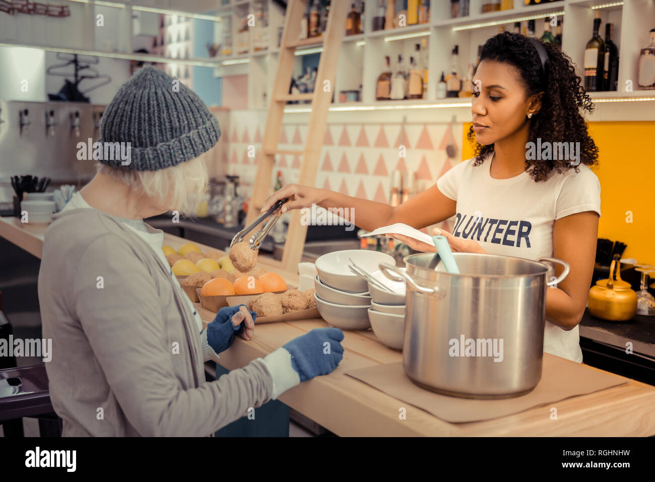 Nice good looking woman serving food for homeless Stock Photo - Alamy