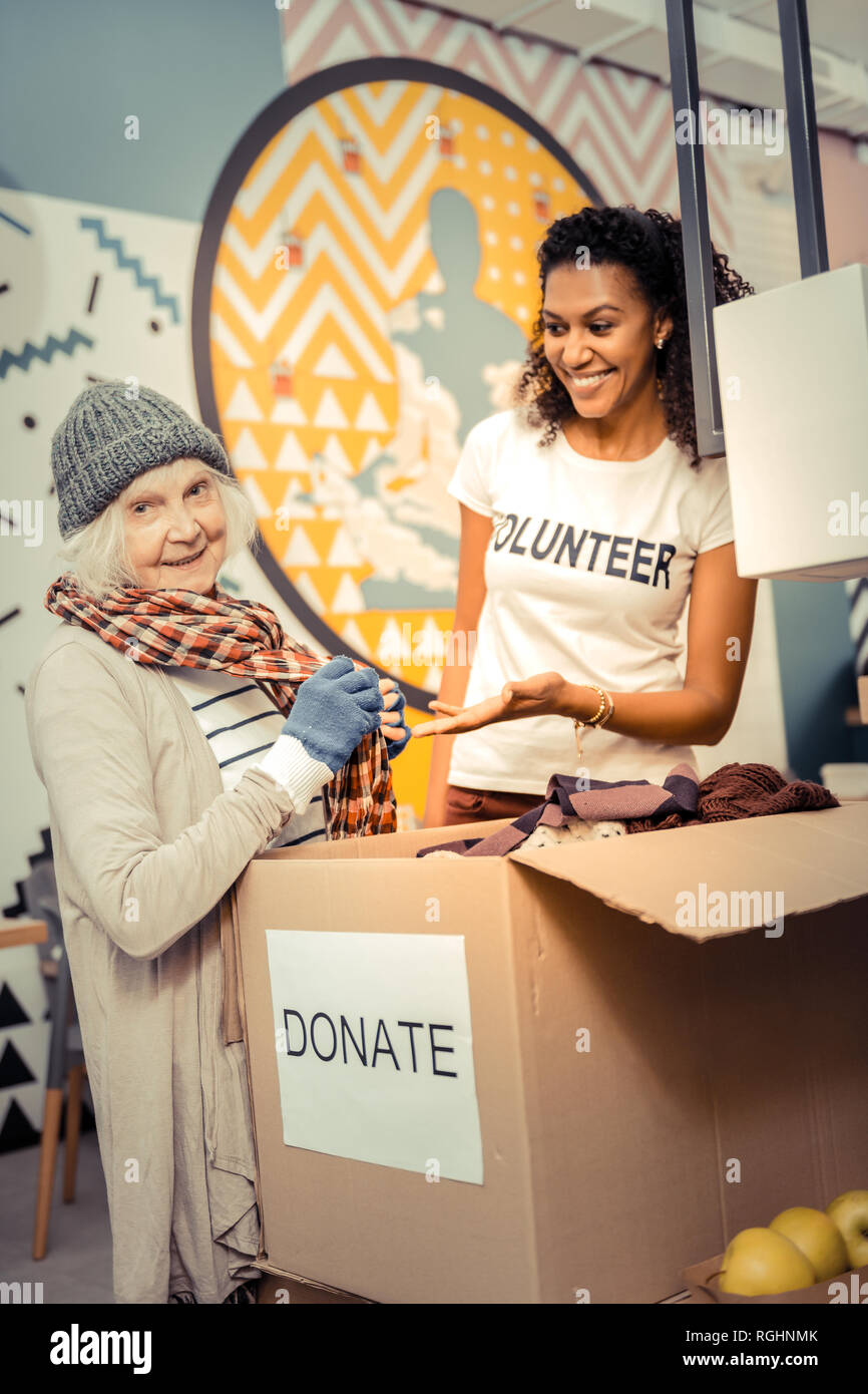 Joyful aged woman standing near the donation box Stock Photo - Alamy