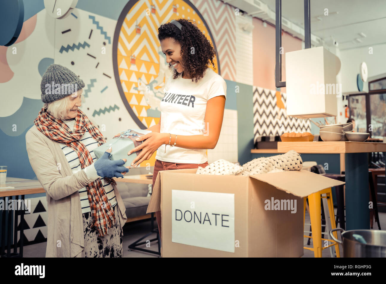 Positive afro American woman giving a nice gift Stock Photo - Alamy