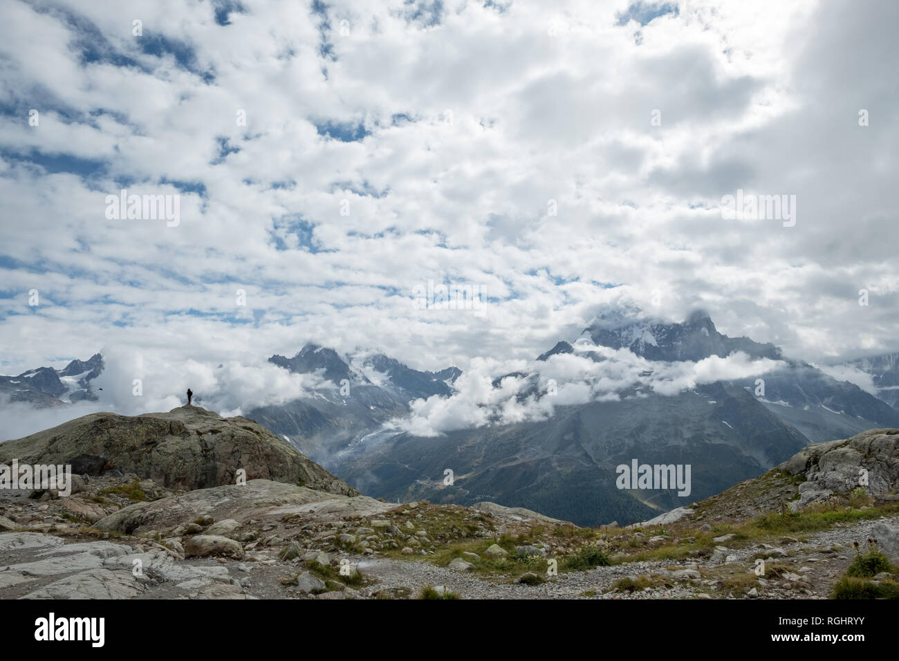 One person stands on rocky outcrop high above Chamonix Valley, looking ...