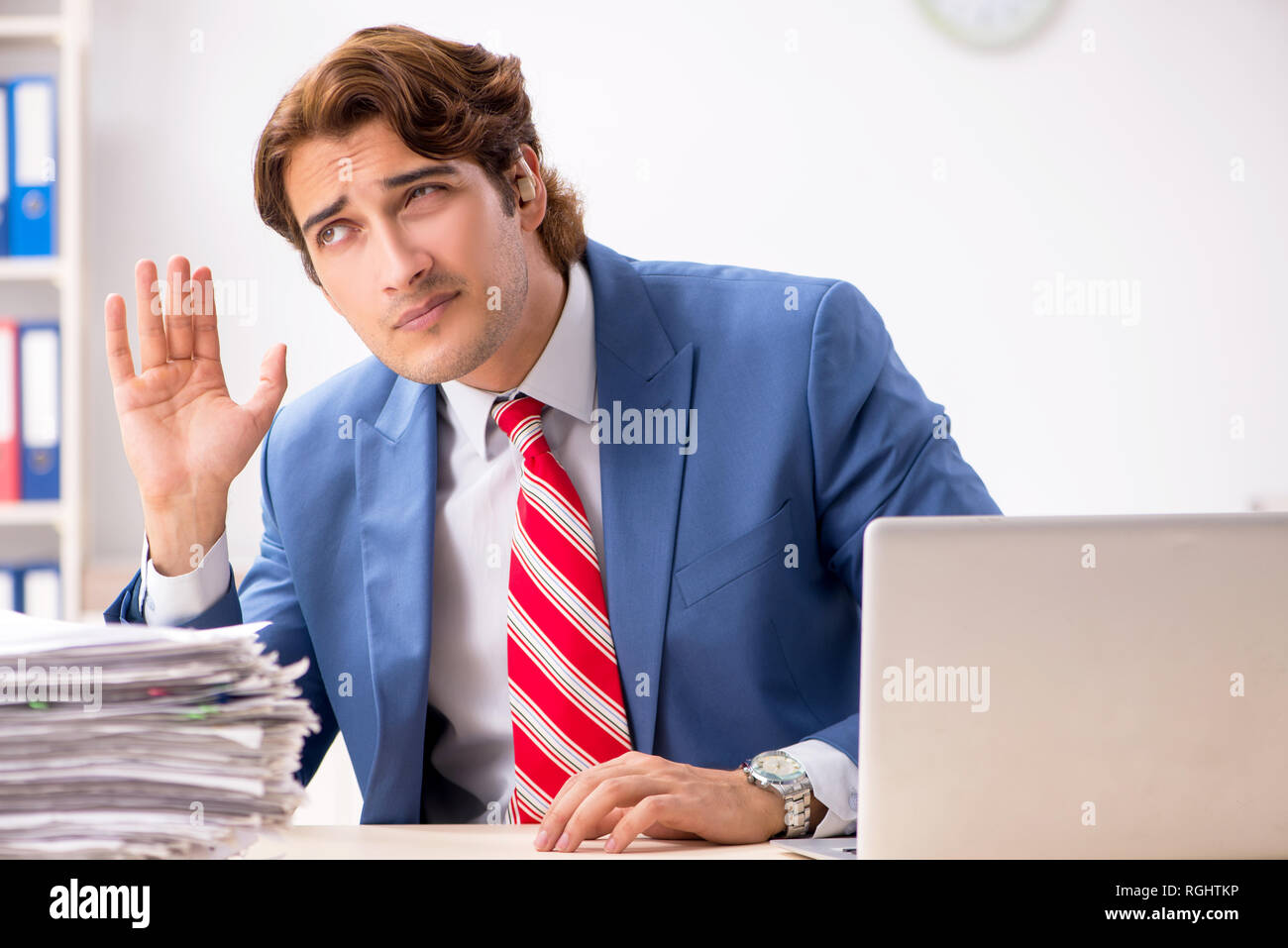 Deaf employee using hearing aid in office Stock Photo - Alamy