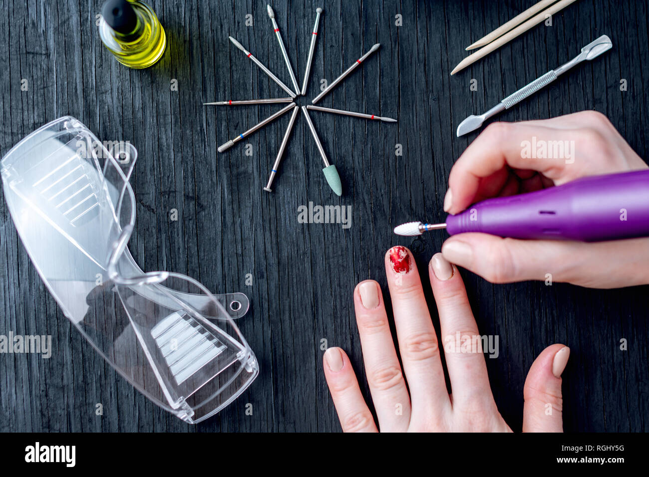 Female manicurist doing a professional manicure hardware using milling ...