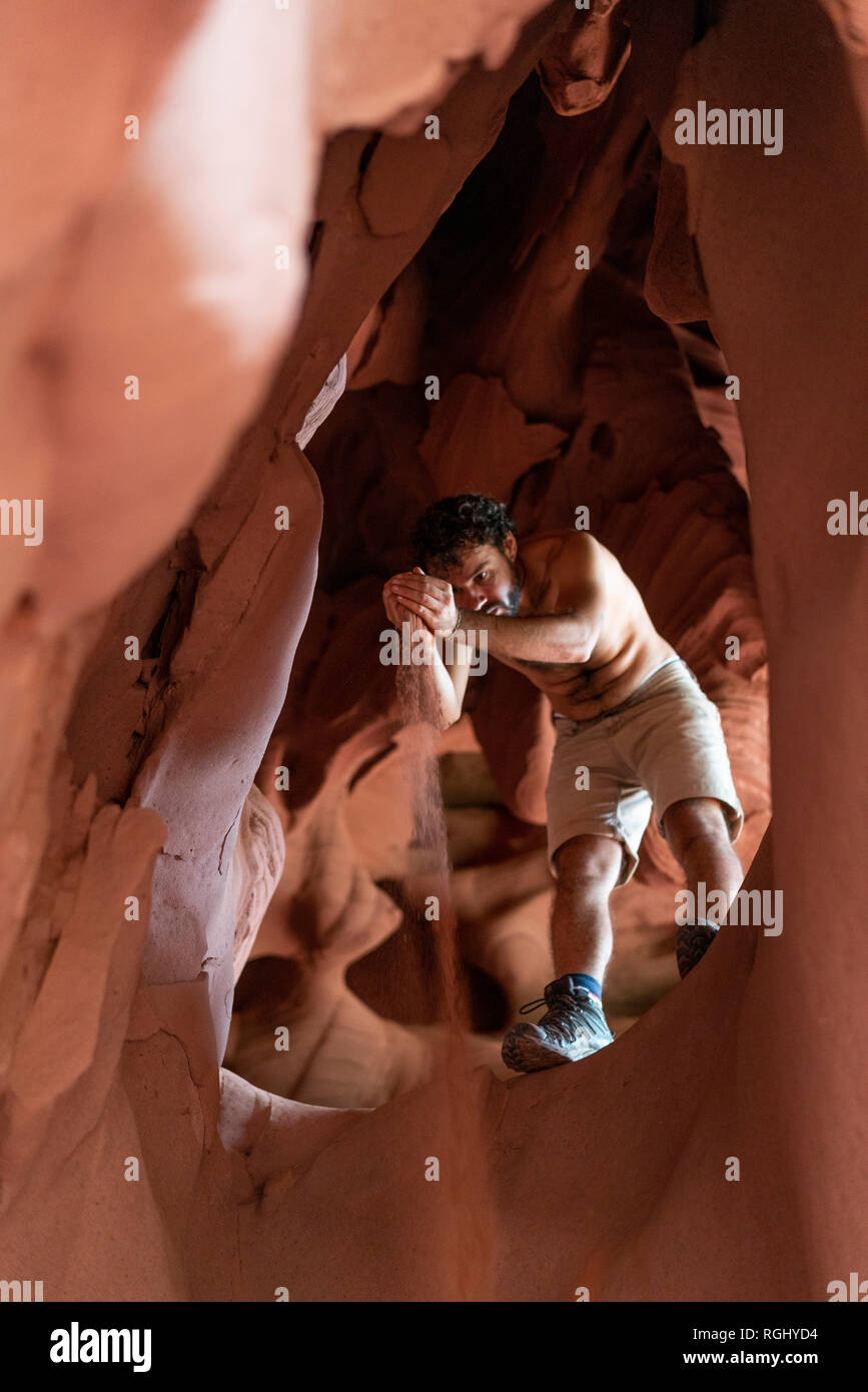 Young man exploring cave Stock Photo - Alamy