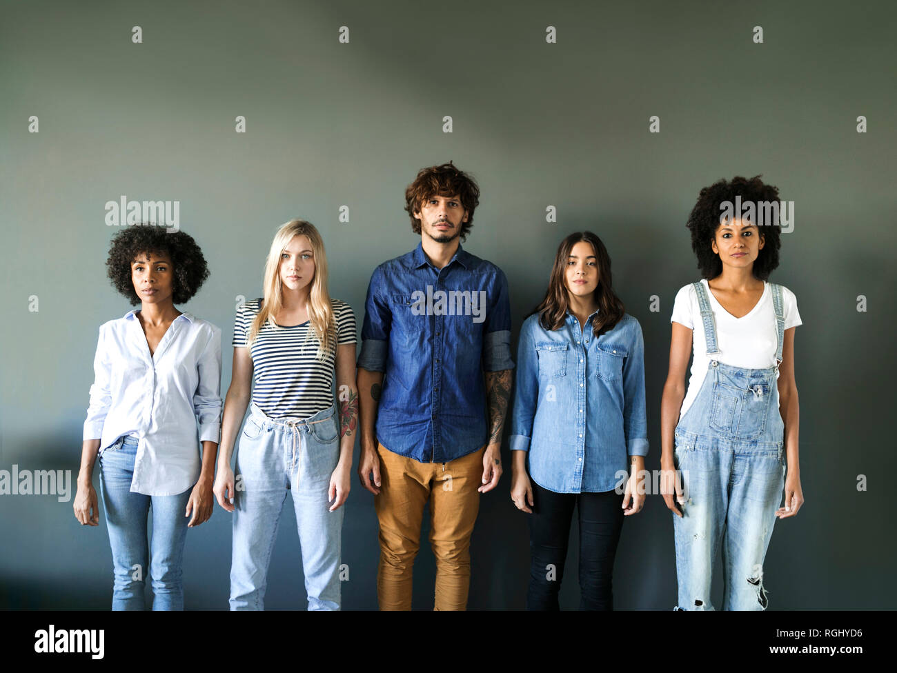Group portrait of friends standing at a wall side by side Stock Photo ...