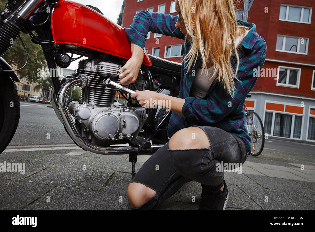 Young woman working on motorcycle Stock Photo - Alamy
