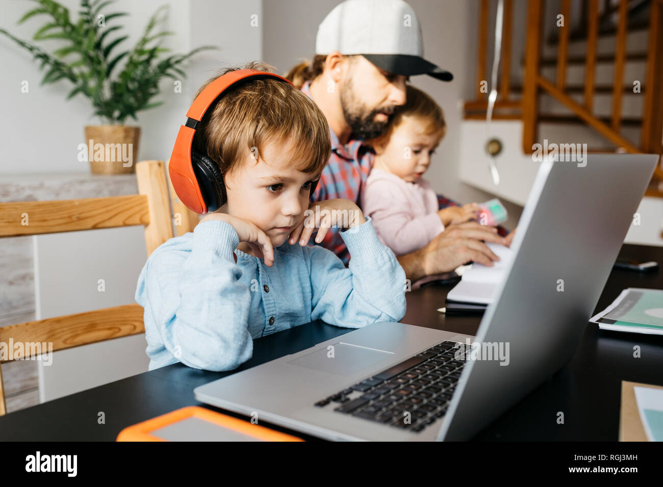 Father working at home, using laptop with his children on his lap Stock ...