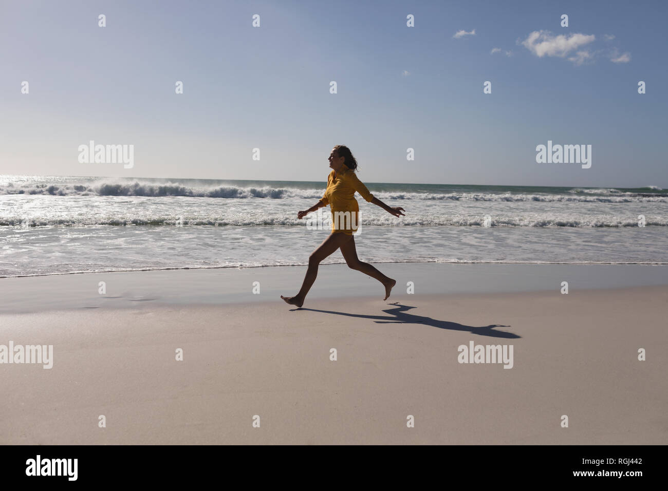 Woman running on the beach near seashore Stock Photo - Alamy