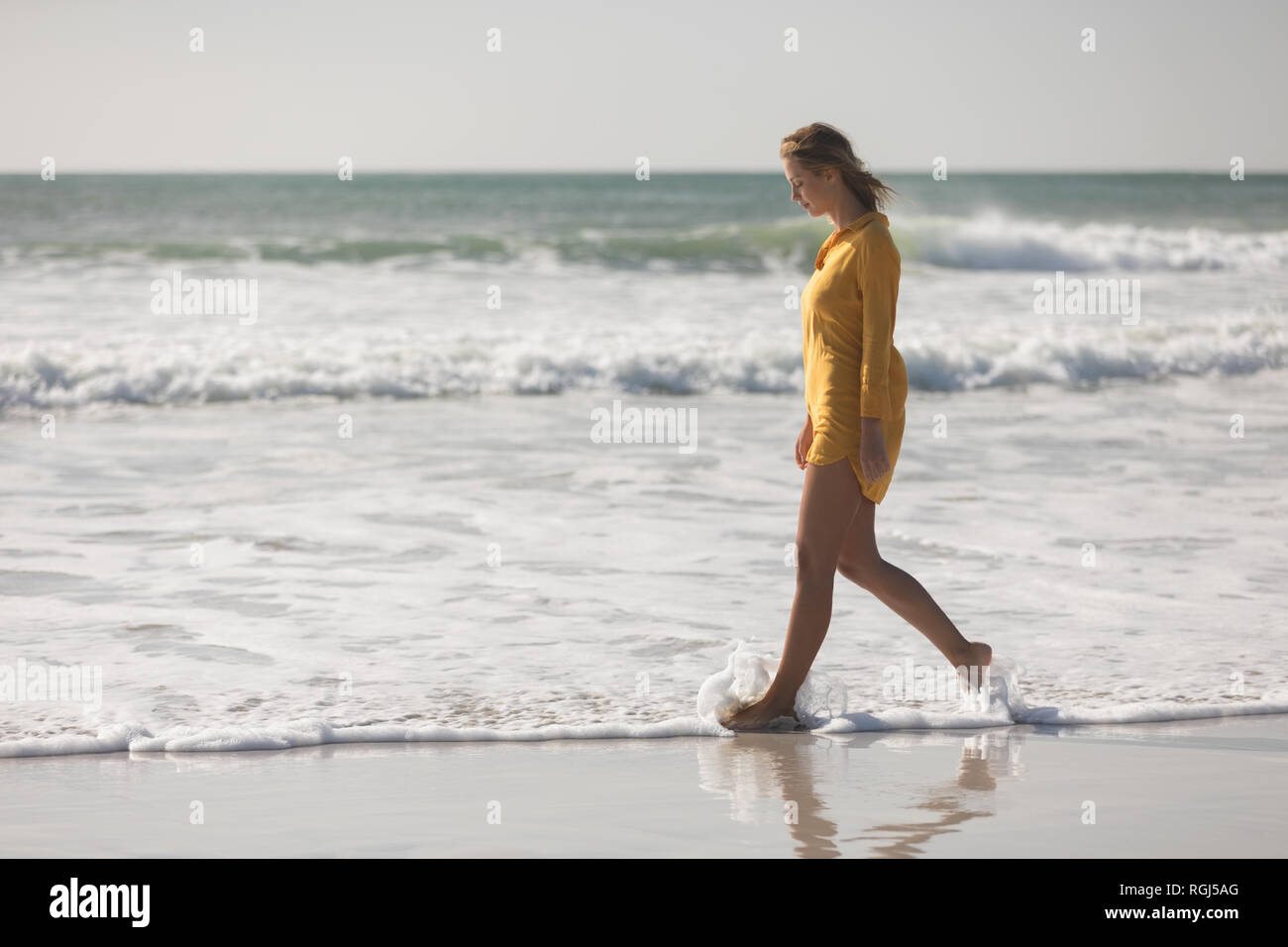 Woman walking on the beach near seashore Stock Photo - Alamy