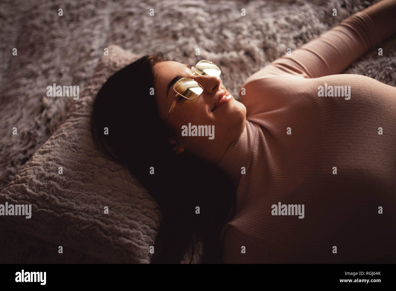 Young Woman lying on bed Stock Photo - Alamy