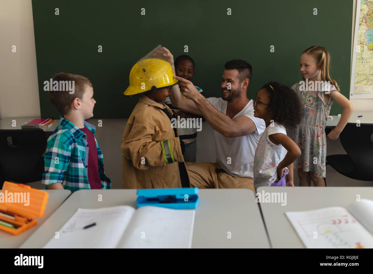 Front view of male Caucasian firefighter helps to wearing fire uniform ...
