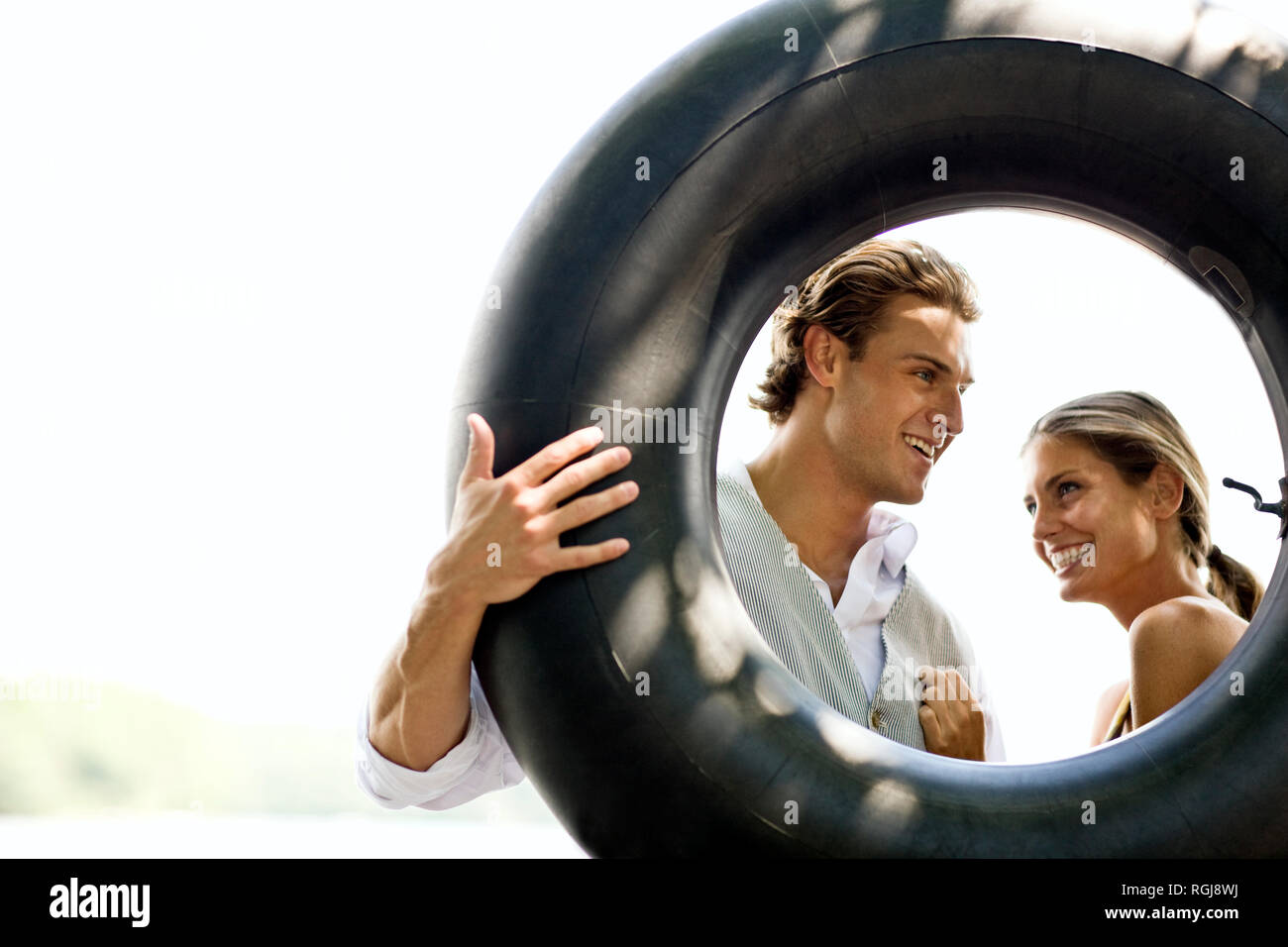 Portrait of a couple through in inner tube Stock Photo - Alamy