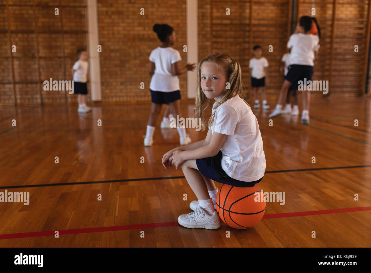Girl sitting on basketball hi-res stock photography and images - Alamy