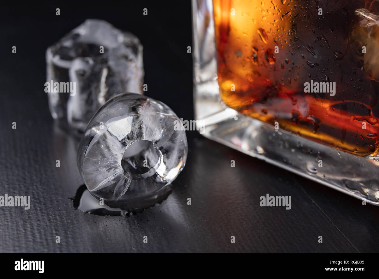 A cold drink with ice on a dark table. A chilled drink in a glass ...
