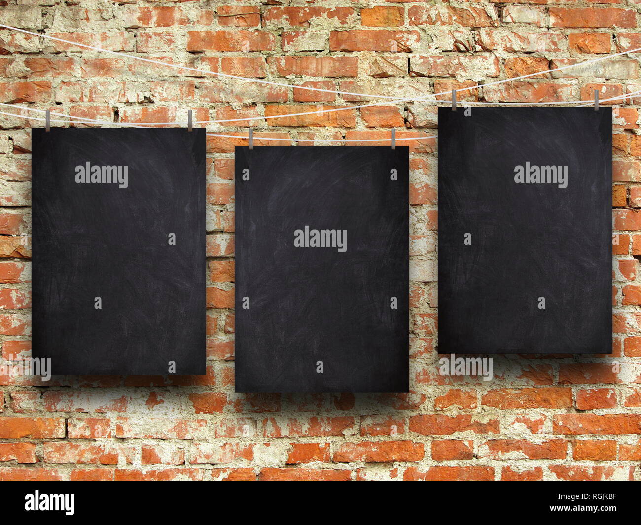 Three blank blackboard frames against orange brick wall background ...