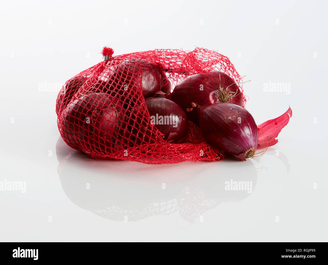 Net with red onions on white ground Stock Photo - Alamy