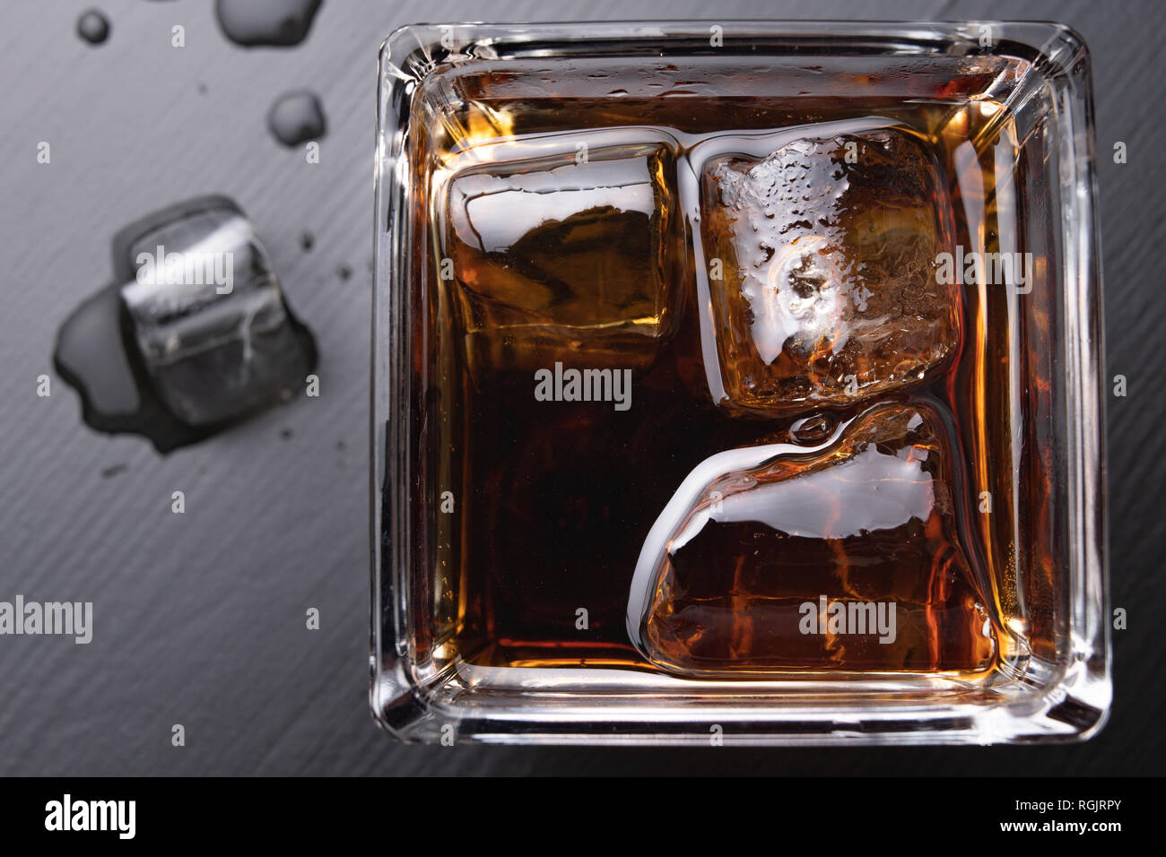 A cold drink with ice on a dark table. A chilled drink in a glass ...