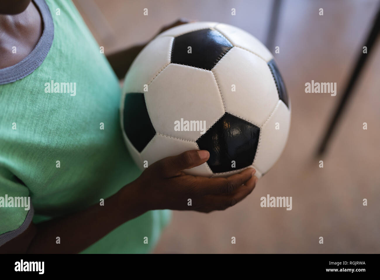 Schoolboy holding football in classroom Stock Photo - Alamy