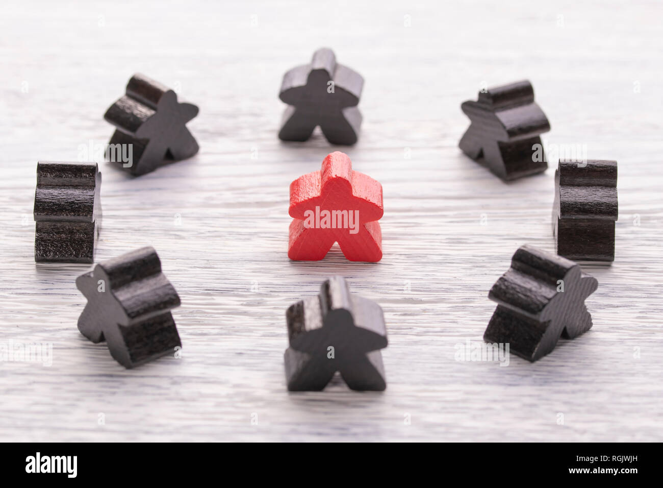 Uniqueness, individuality and difference. Red wooden figure in a crowd ...