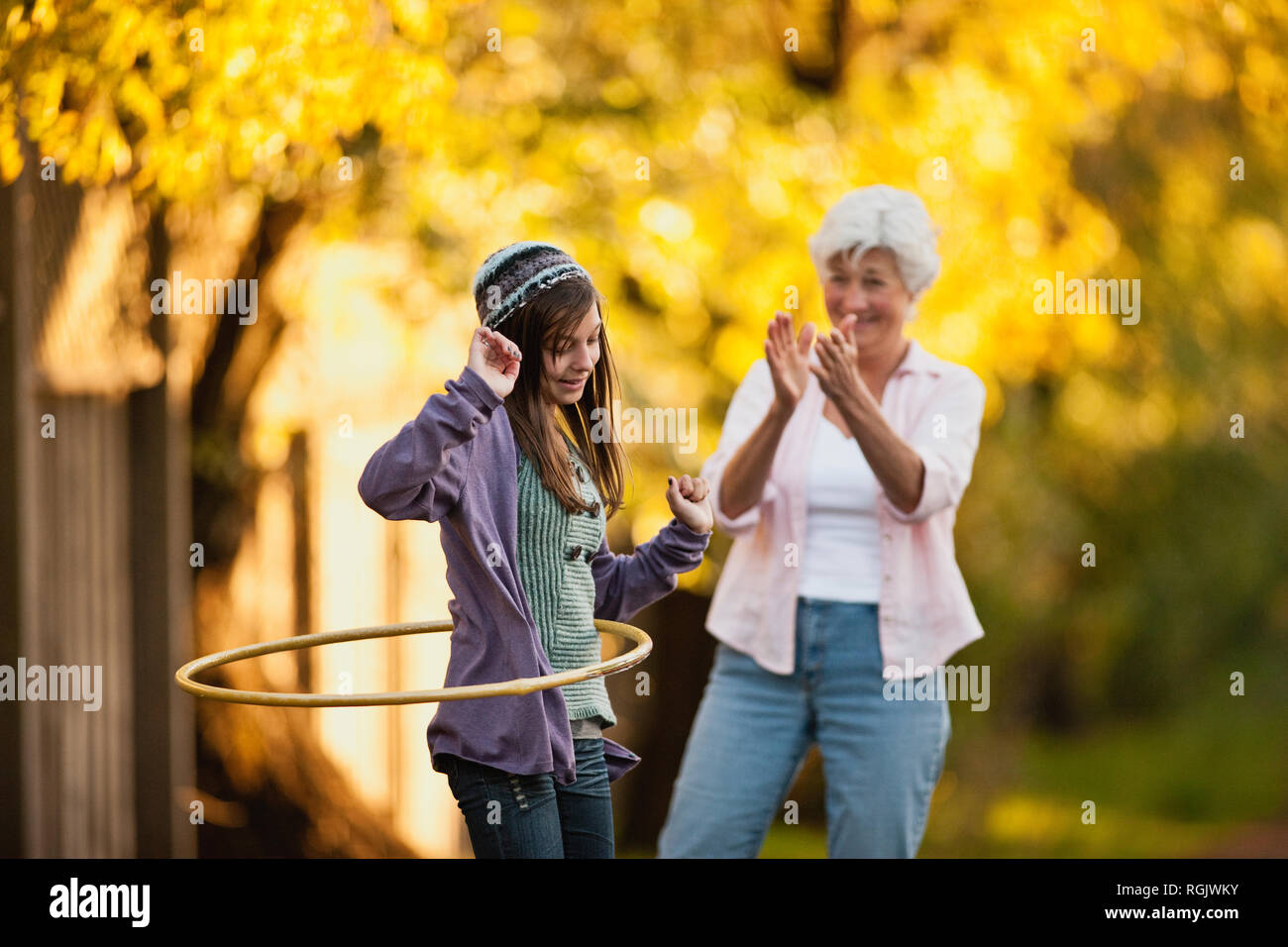 Senior woman watches her granddaughter hula hooping Stock Photo - Alamy