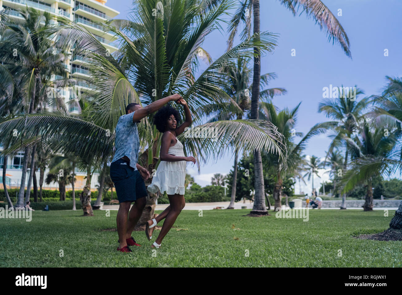 USA, Florida, Miami Beach, happy young couple dancing in a park in ...
