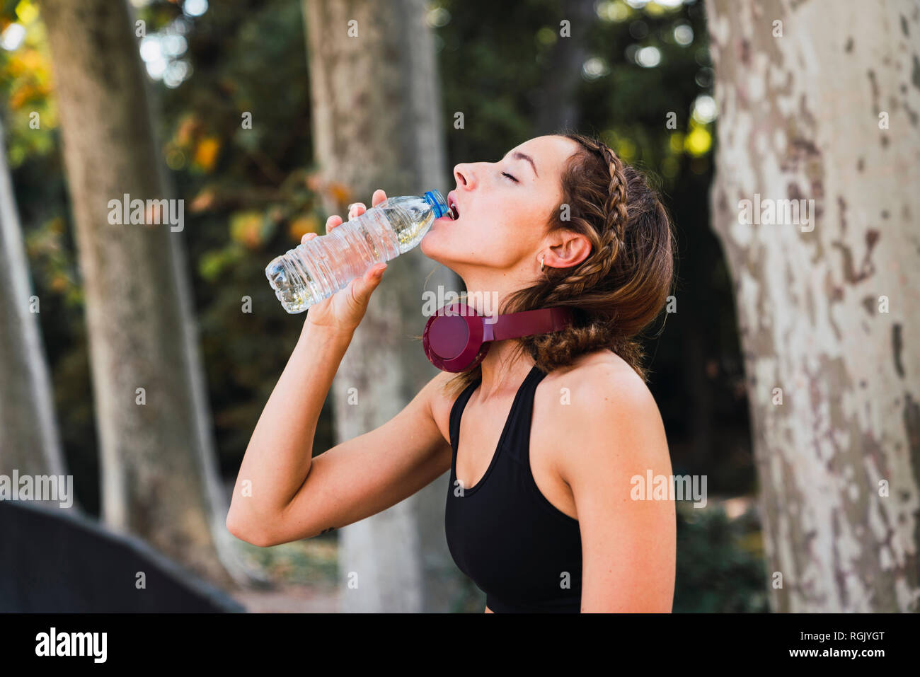 Fit young woman taking a break, drinking water Stock Photo - Alamy