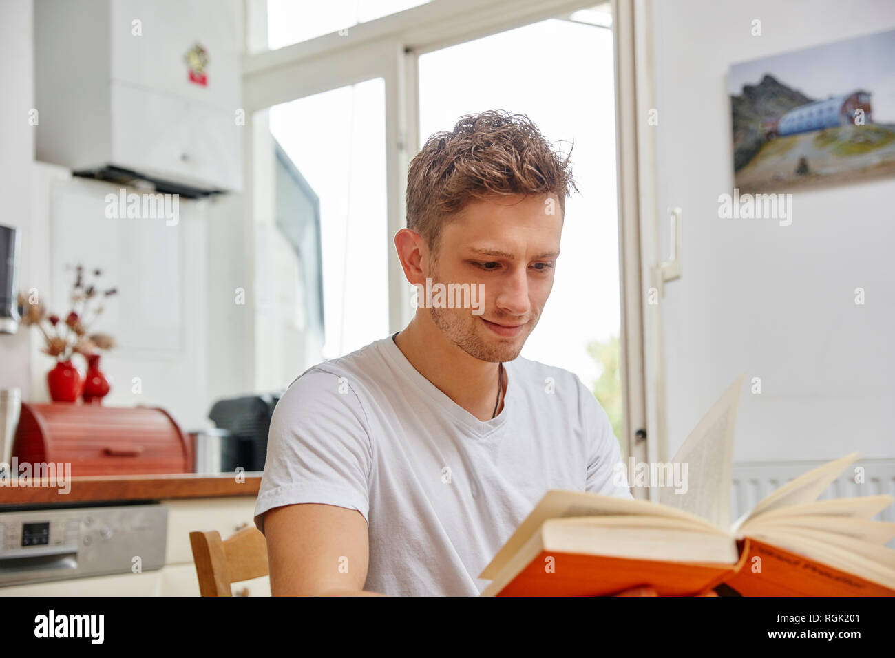 Smiling young man reading hi-res stock photography and images - Alamy