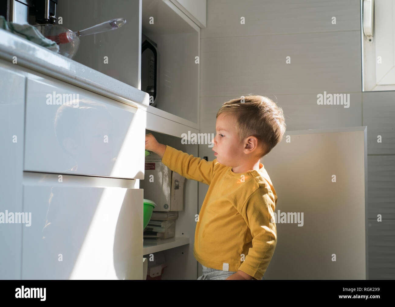 Little boy playing in the kitchen Stock Photo - Alamy
