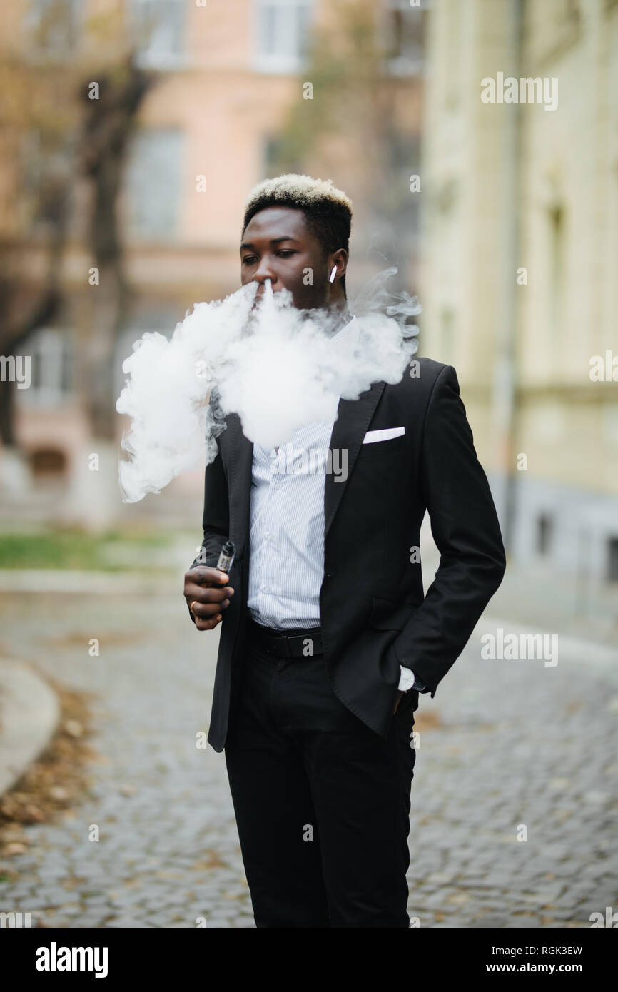 Young african man smoking e cigarette hi-res stock photography and ...