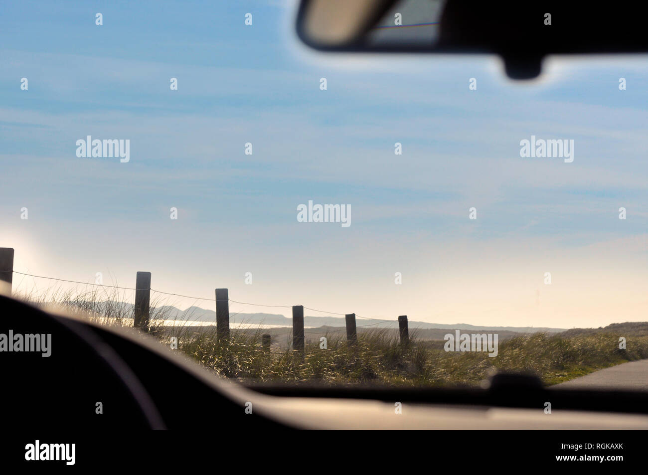 View out of a car with a rural roadside and the sky in front by ...
