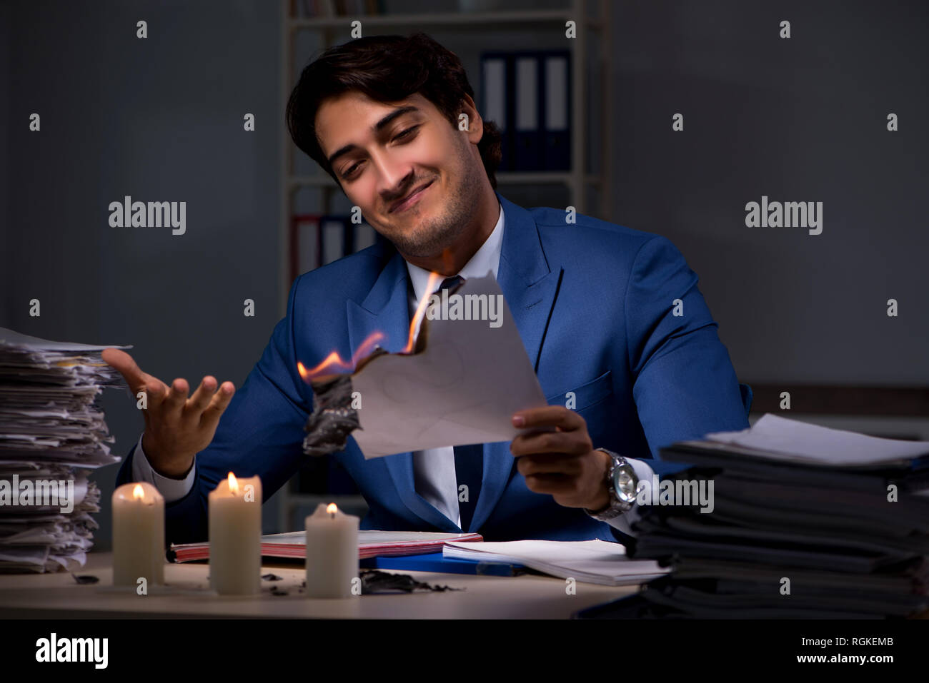 Businessman burning the evidence late in office Stock Photo - Alamy