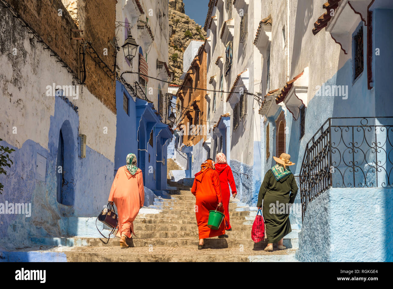 4 Women in traditional clothing walking up the stairs in the medina of ...