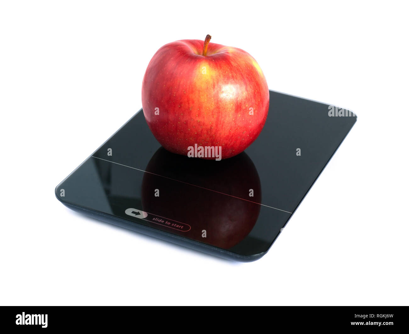 Big tasty red apple on black kitchen scales isolated on white ...