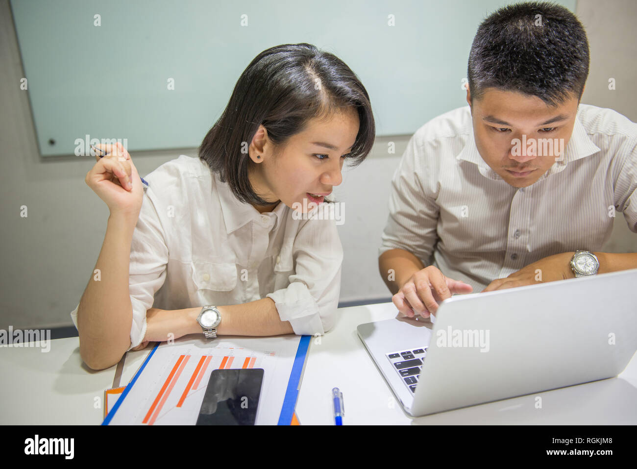Two Asian office employees working in a team Stock Photo - Alamy