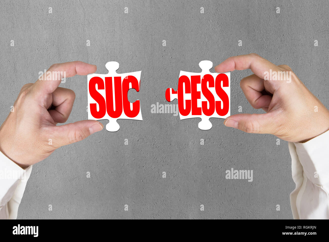 Connecting two puzzles for success concrete wall background Stock Photo ...