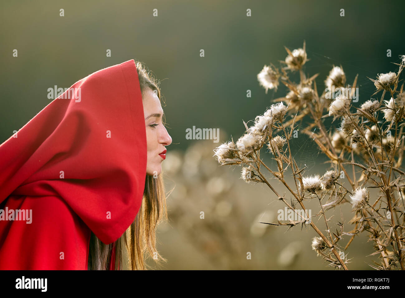 Woman dressed as Red Riding Hood in various postures in the forest ...