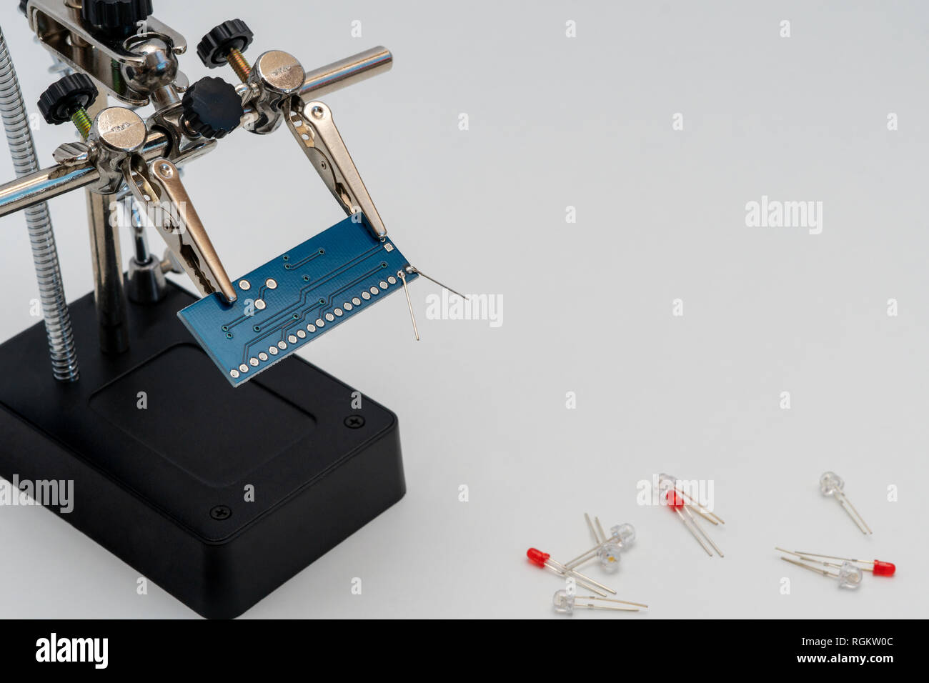 Blue circuit board in soldering helping hands before technological ...