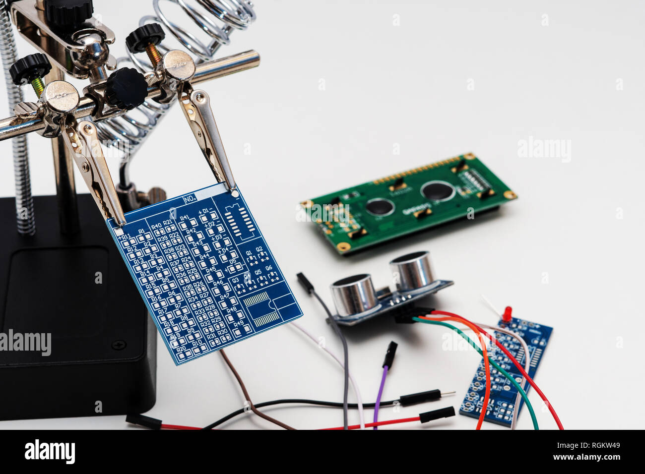 Blue circuit board in soldering helping hands before technological ...